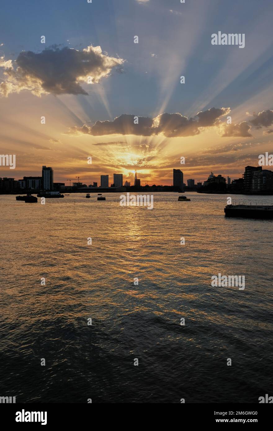 Golden rays of sun shine out from behind the Shard in the distance over ...