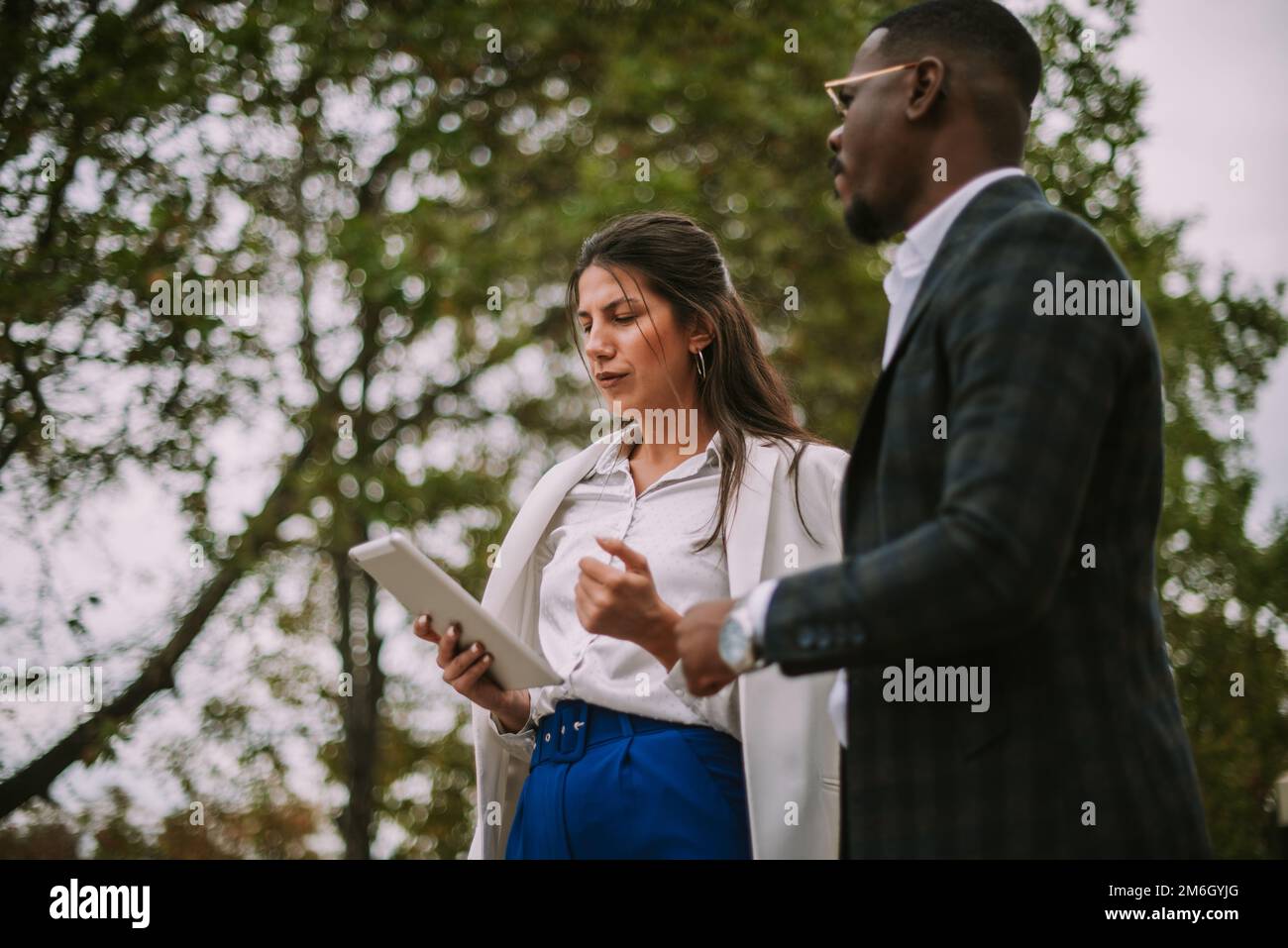 Close up of two business people talking while standing Stock Photo - Alamy