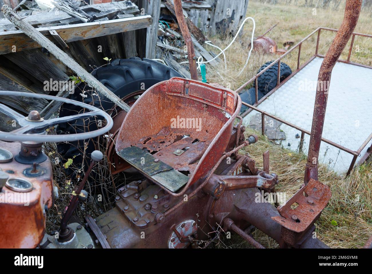Old rusty tractor stands on a meadow Stock Photo - Alamy