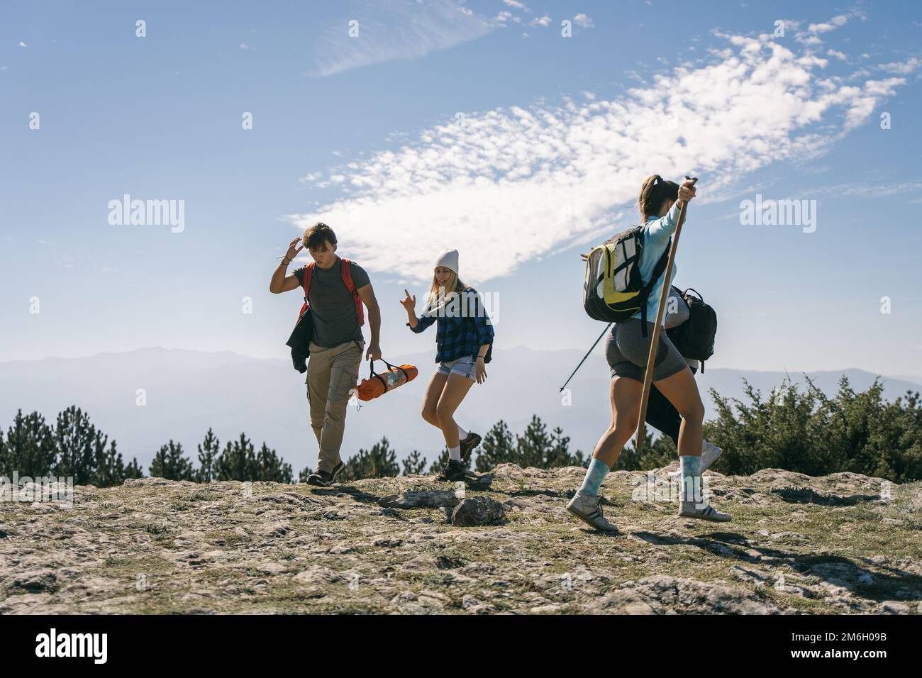 Four hikers walking at the top of the mountain Stock Photo - Alamy