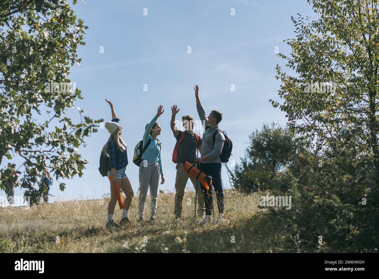 Happy hiking couples celebrating successfully reaching the top of the ...