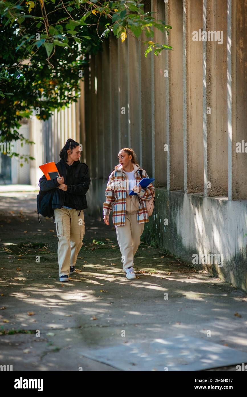 Cute high school female students are having a serious conversation ...