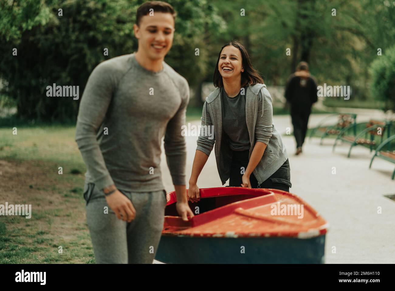 Beautiful couple having fun while carrying the kayak and walking in the ...