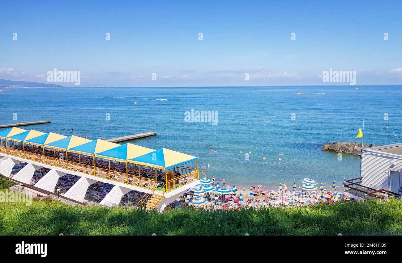 View of the beach with people, sun loungers, an air solarium with a ...