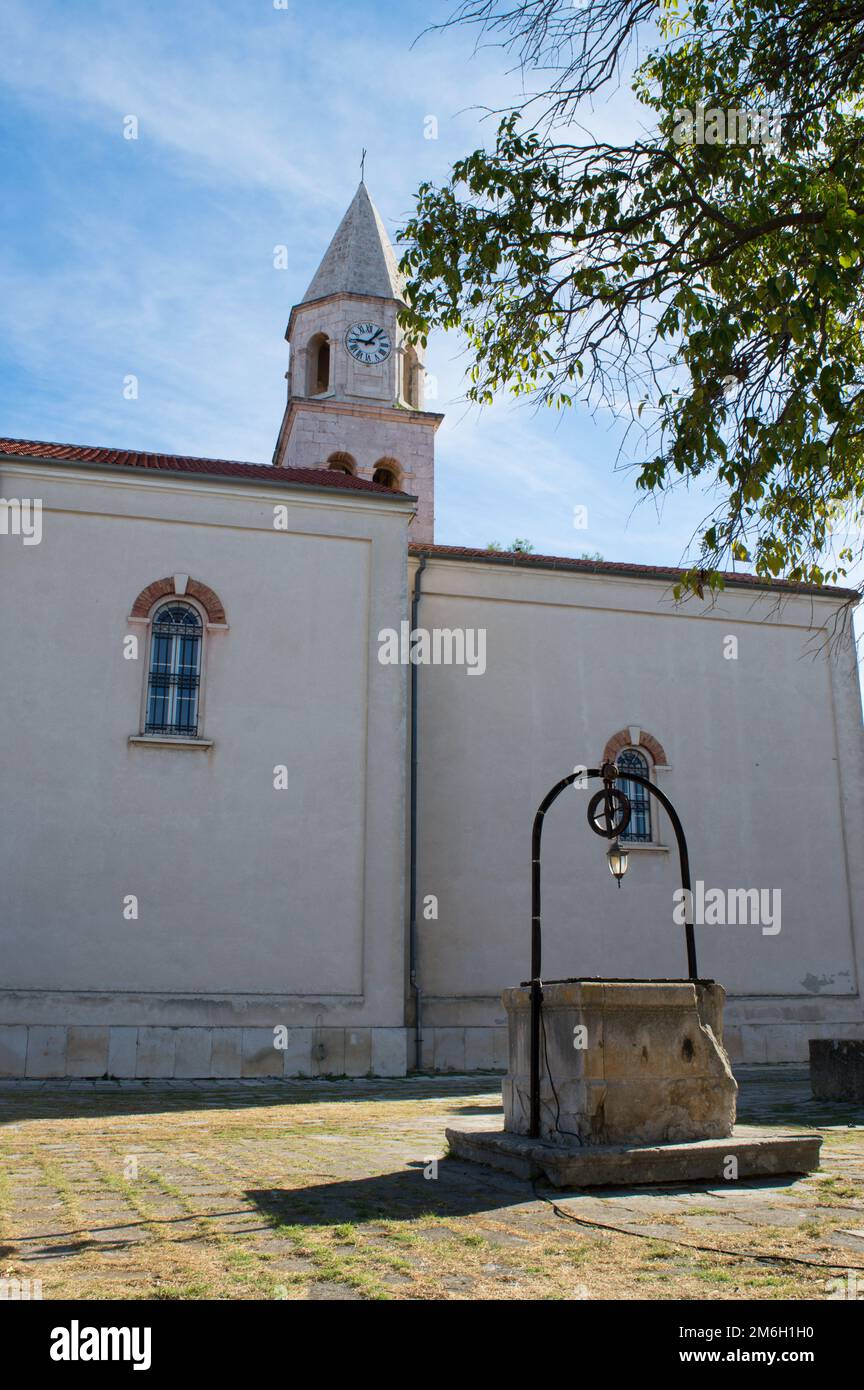 Catholic church of St Anastasia with bell tower, and water well in ...
