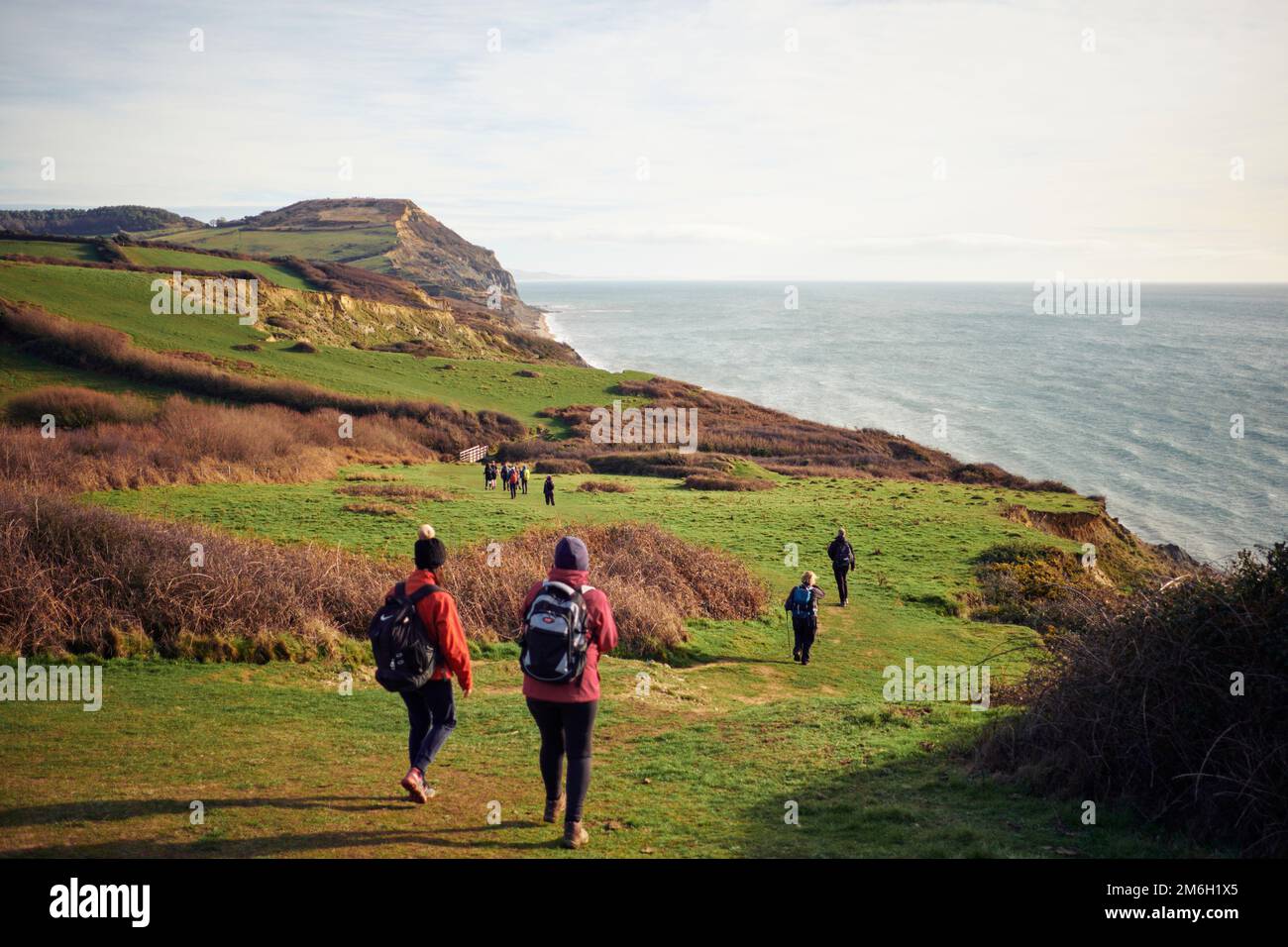 Hikers walk along the Jurassic coast in southern England on a cold ...