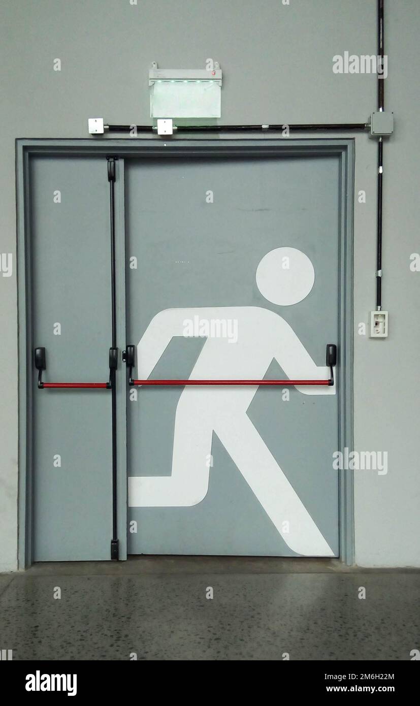 Emergency exit door with running person graphic Stock Photo - Alamy