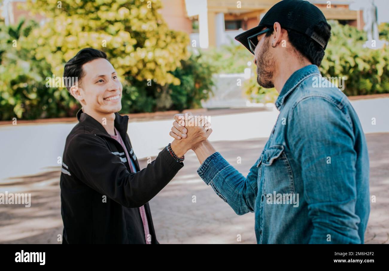 Two people shaking hands on the street. Two teenage friends shaking ...