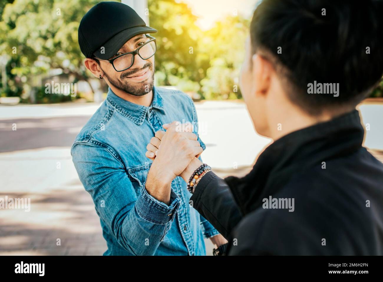 Concept of two friends greeting each other and shaking hands on the ...