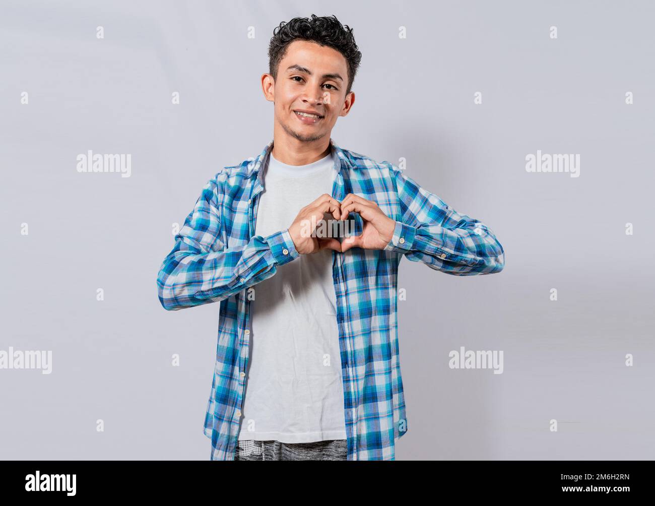 Smiling guy making heart shape with hands isolated. Happy man making ...