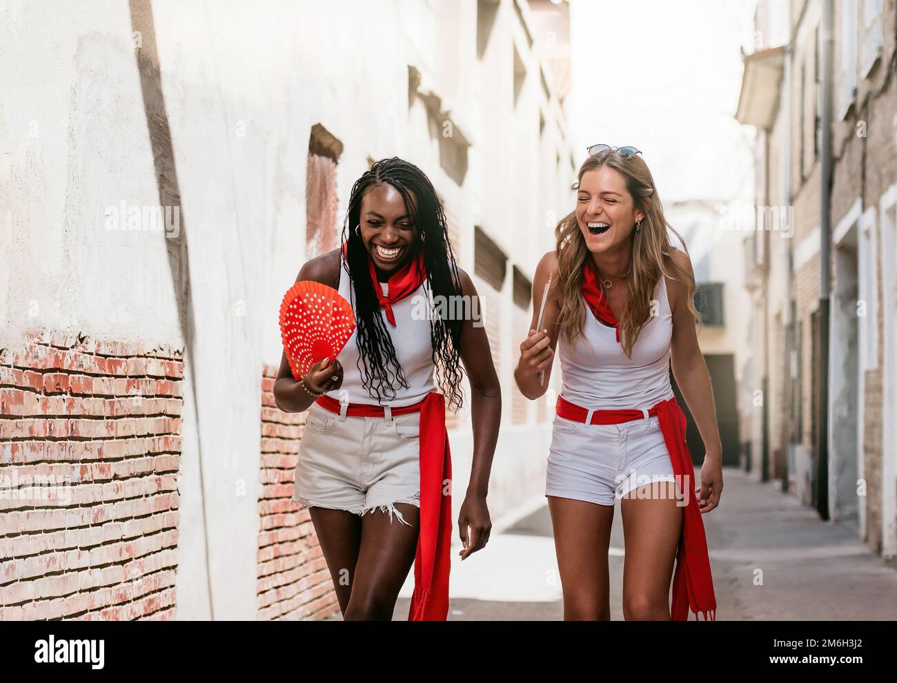 two young caucasian and afro-american women enjoy the traditional ...