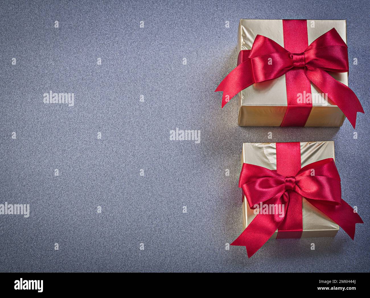 Boxed presents with red knots on grey background copy space holidays ...