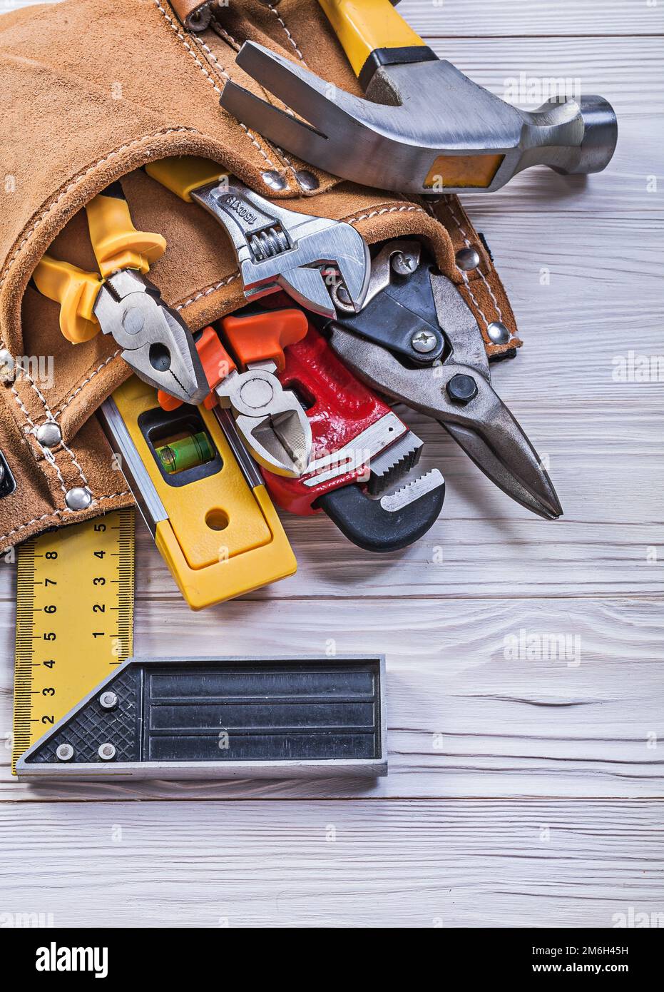 Brown leather toolbelt with construction tools on wood board directly ...