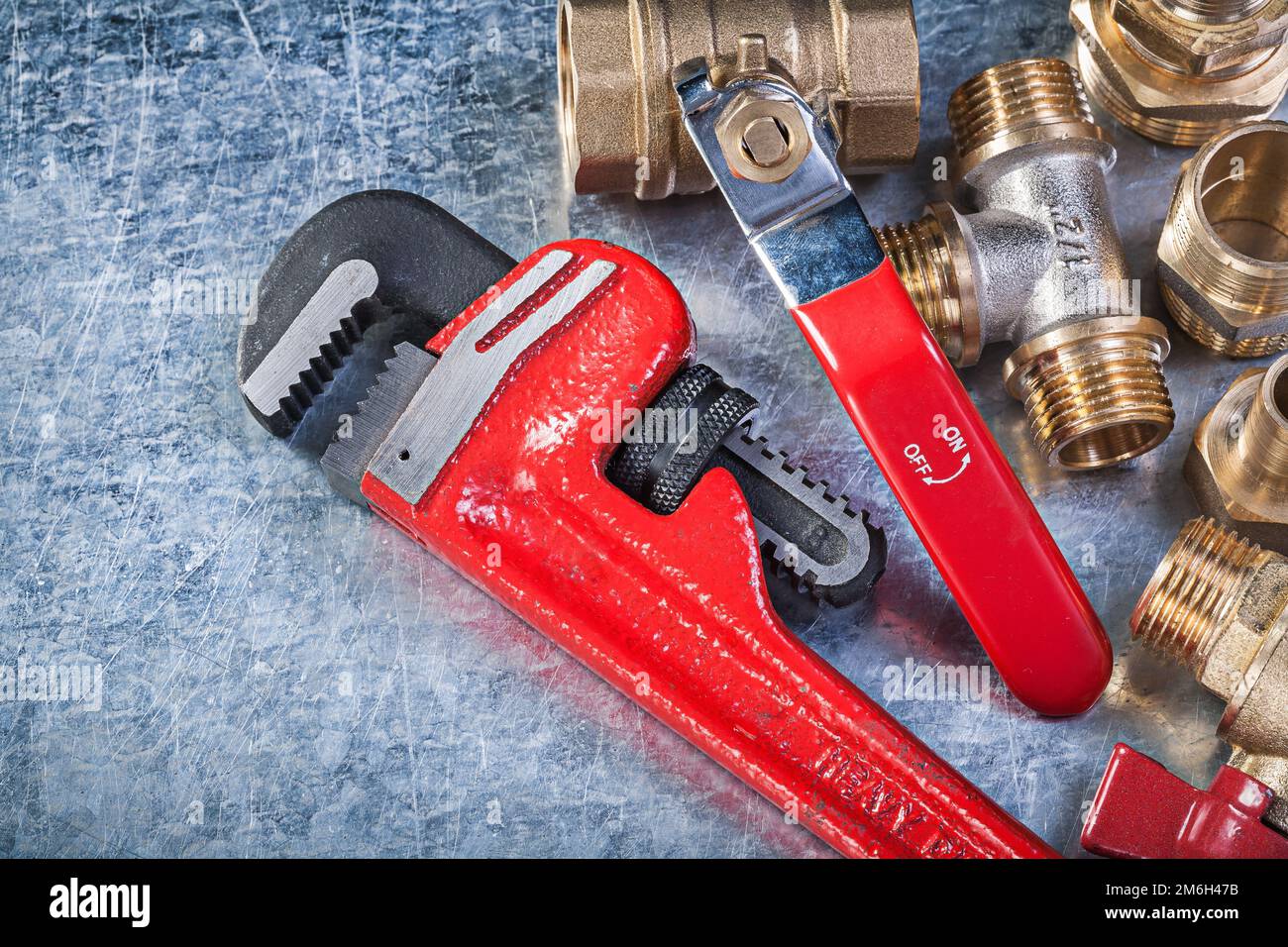 Brass pipe connectors monkey wrench gate valve on metallic background ...
