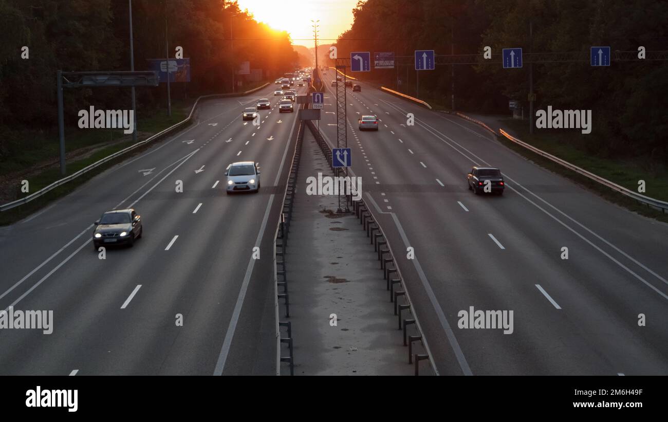 Moving cars on the motorway at sunset time. Highway traffic at sunset ...