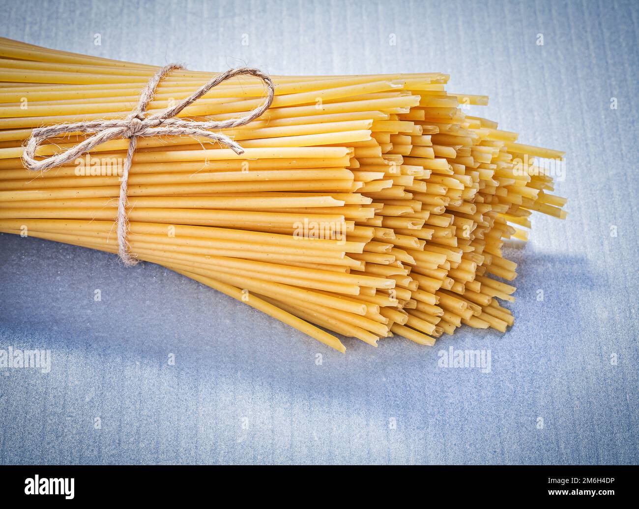 Bunch of uncooked spaghetti on blue background food and drink concept ...