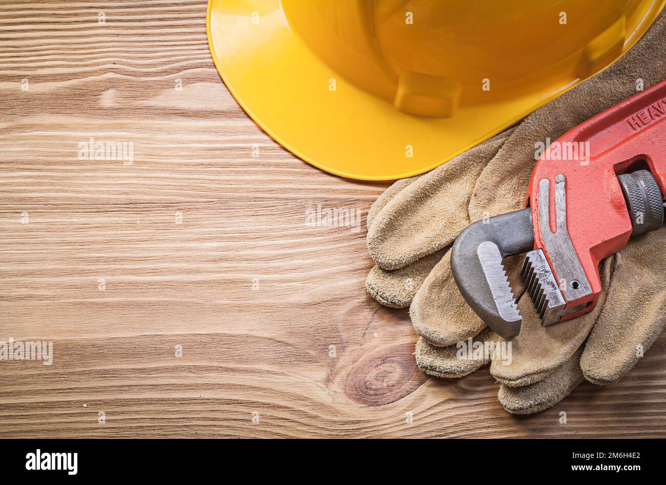 Building helmet protective gloves monkey wrench on wooden board ...