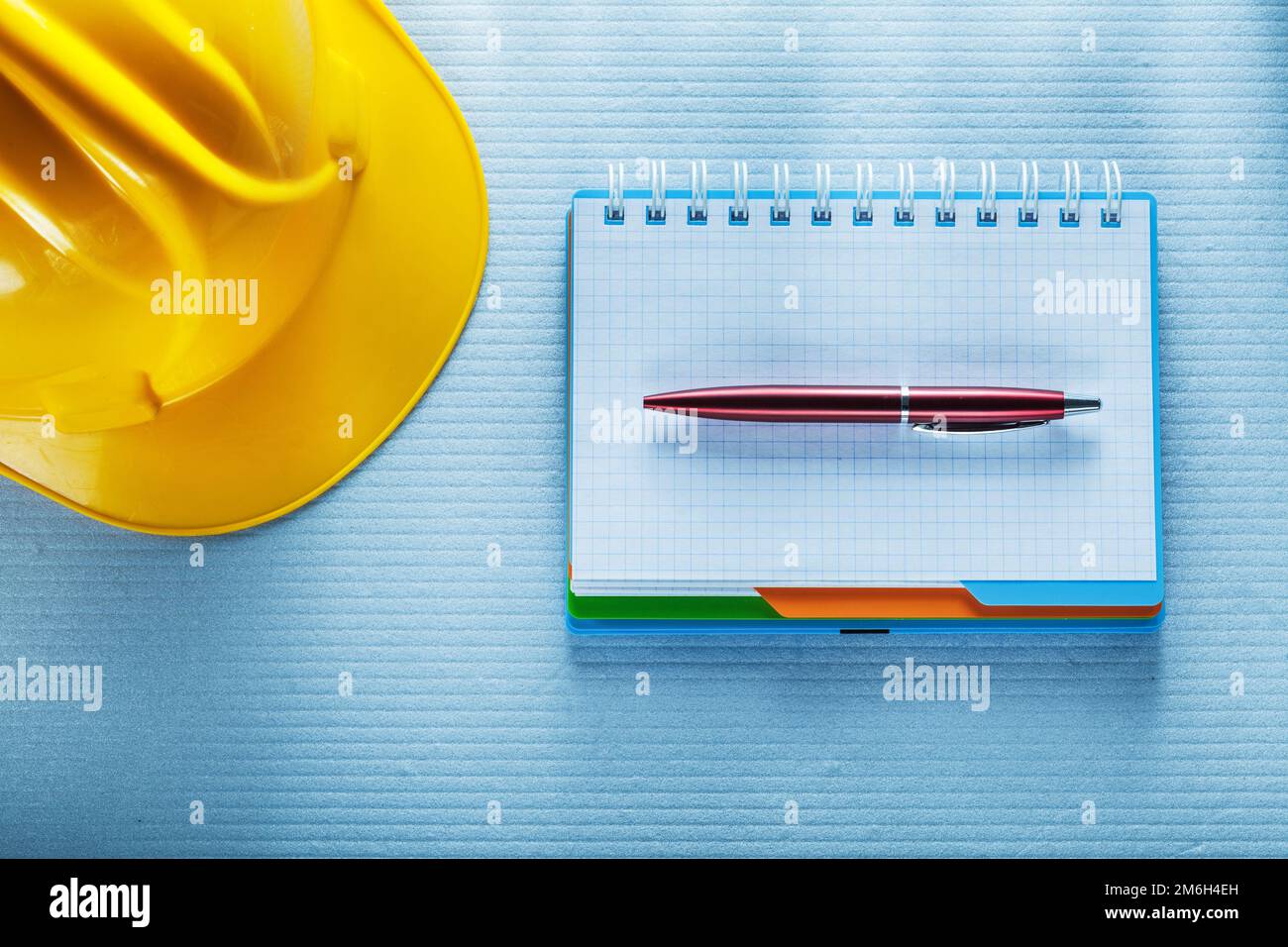 Checked notebook pen building helmet Stock Photo - Alamy