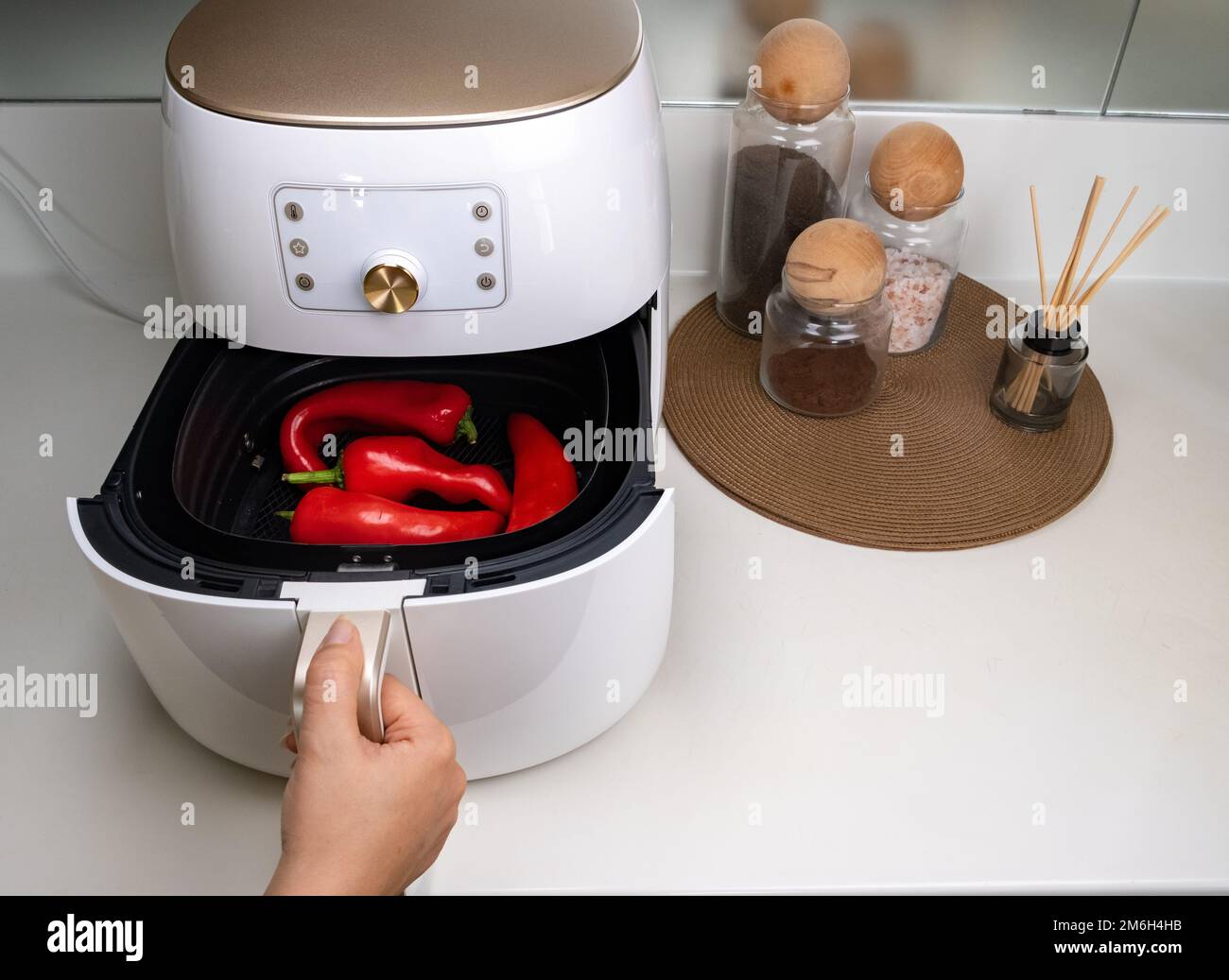 Cooked paprika air fryer for healthier lean food. Woman cooking ...