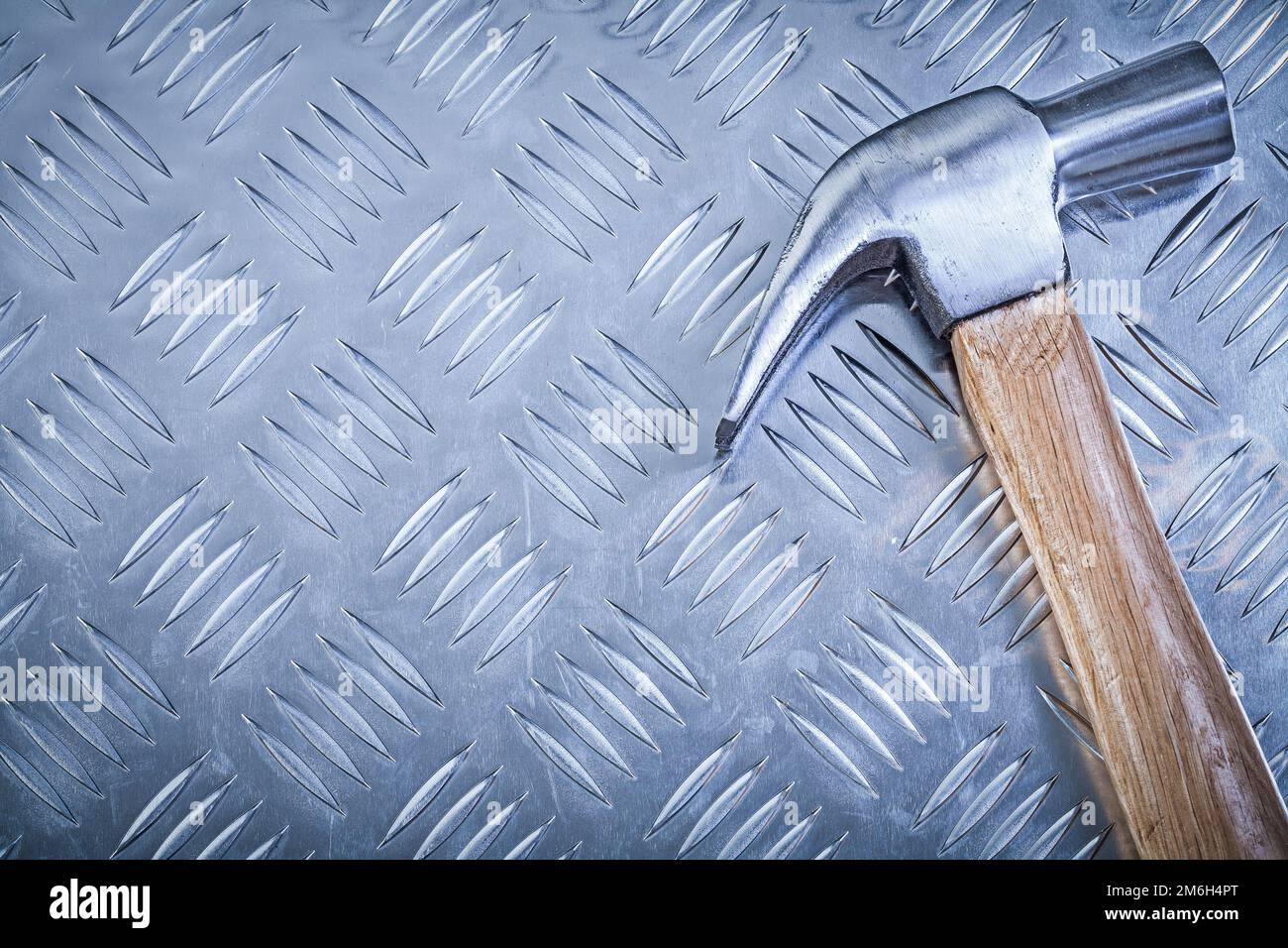 Claw hammer with wooden handle on corrugated metal plate construction ...