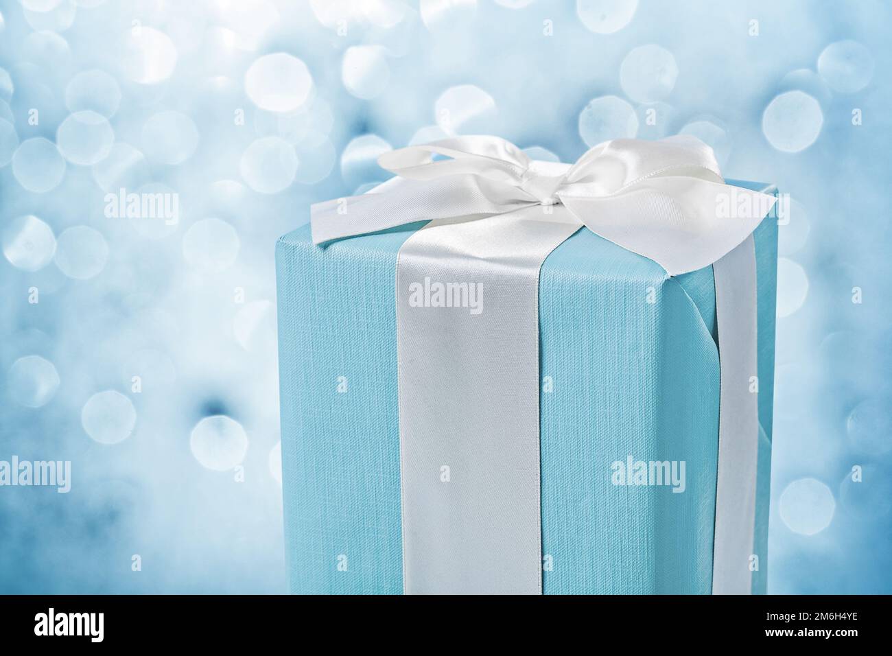 close up view blue gift box with white bow on blurred background Stock ...
