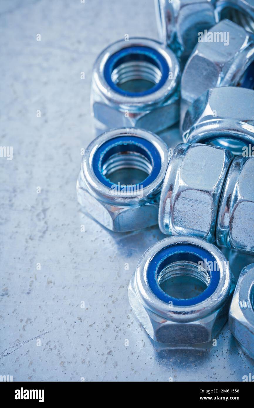 Collection of steel screw nuts on flat metallic background construction ...