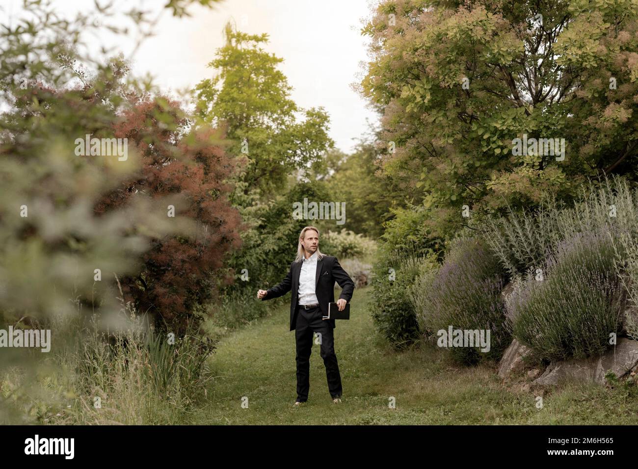 Businessman, 40, barefoot in suit, walks in nature Stock Photo - Alamy