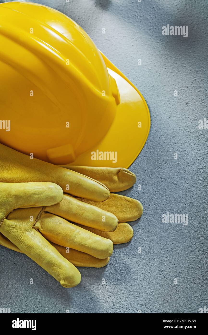 Hard hat protective gloves on concrete surface construction concept ...