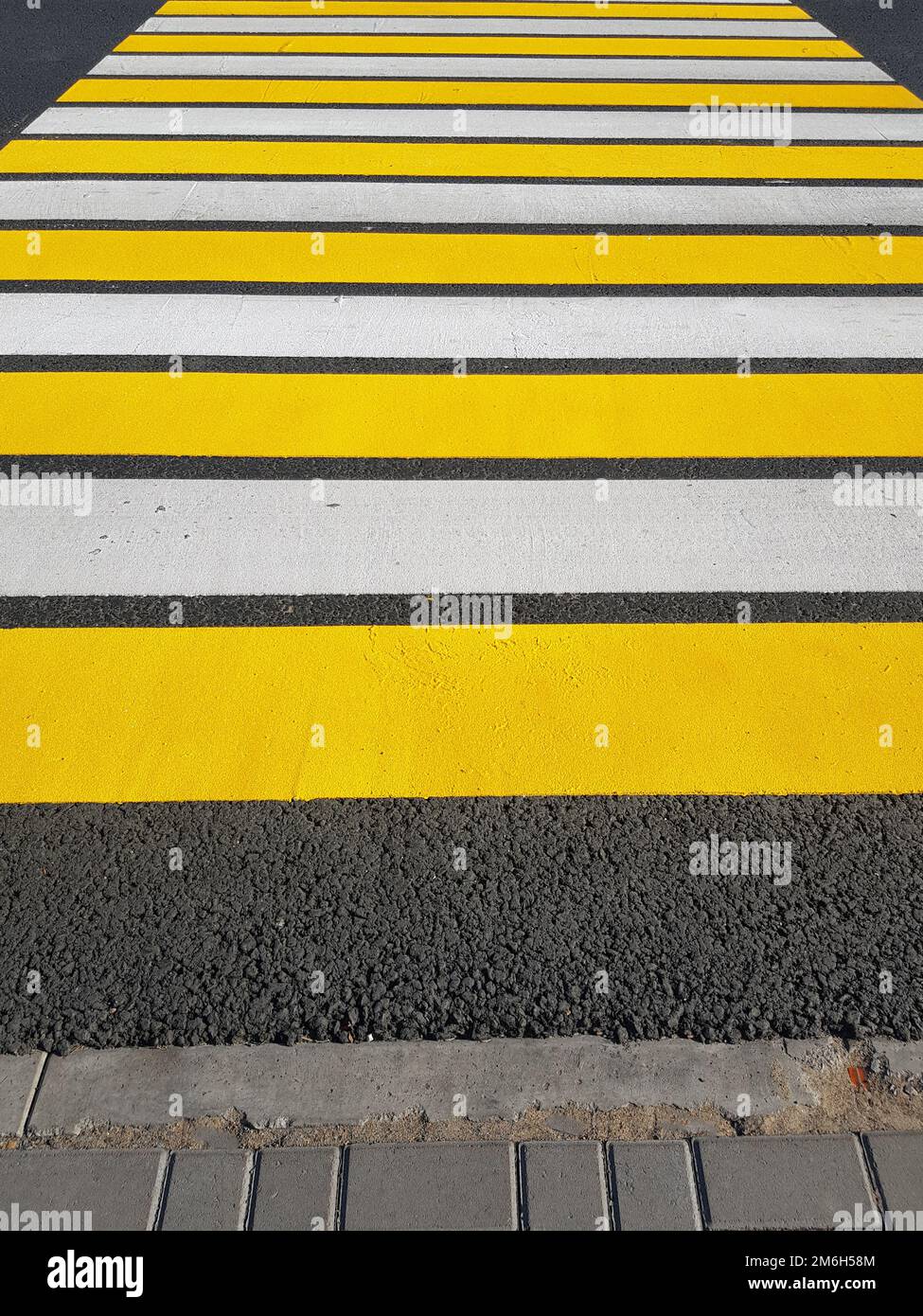 Freshly painted pedestrian crossing with yellow and white markings on ...