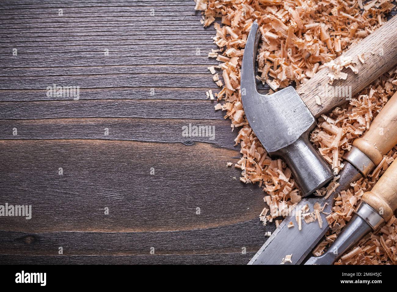 Horizontal view of claw hammer and metal flat chisels in wooden ...