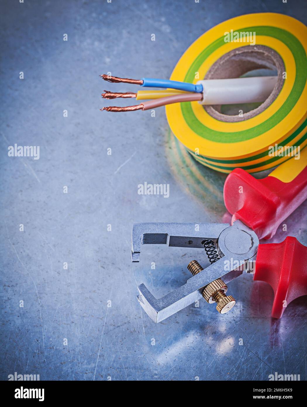 Insulated strippers electricians tape electrical wires on metallic ...