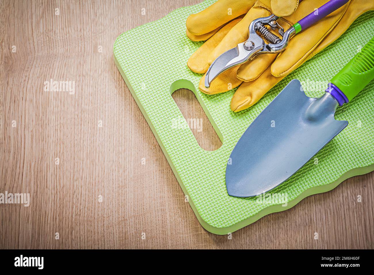 Leather gloves garden foam kneeling mat hand spade secateurs on wood ...