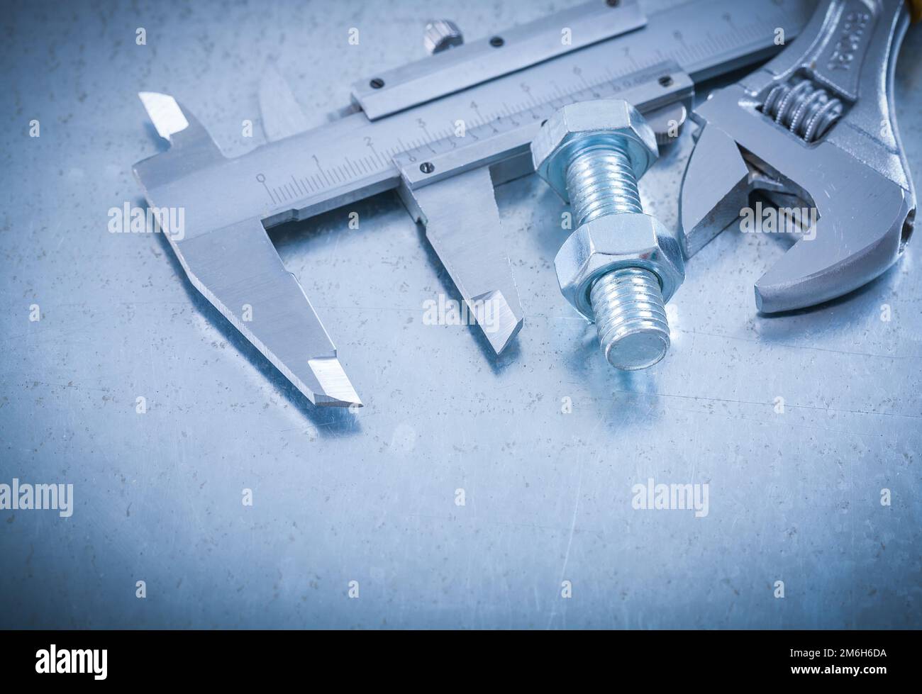 Metal caliper adjustable key screw bolt and nut on scratched metallic ...