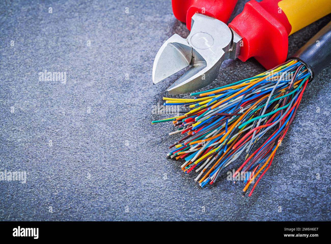 Multicolored electric cables nippers on black background electricity ...