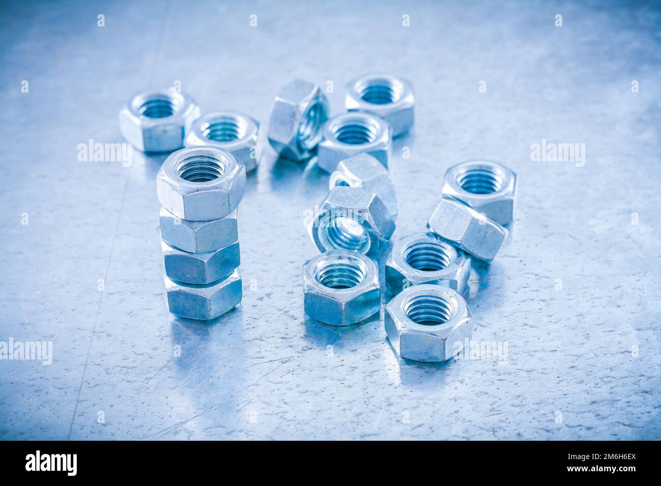 Metal threaded screw nuts on metallic background construction concept ...