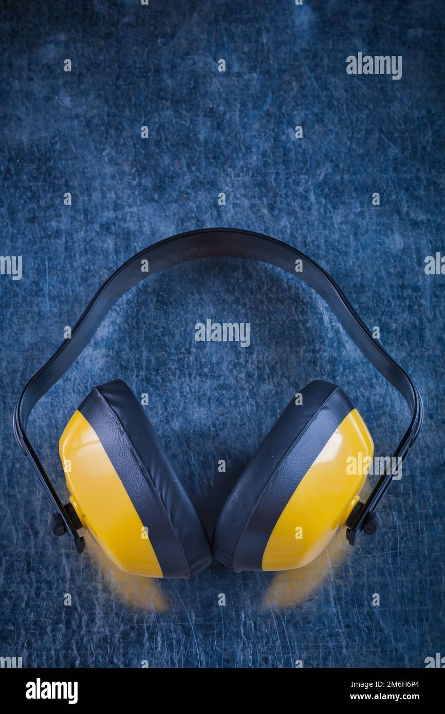 Noise insulation ear muffs on metallic surface construction concept ...