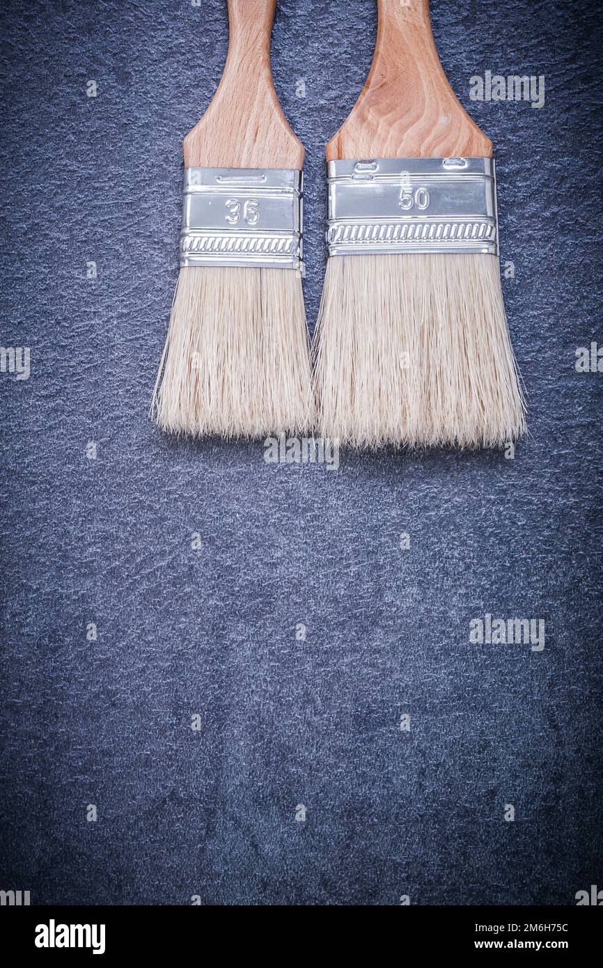 Paint brushes on black surface vertical image construction concept ...