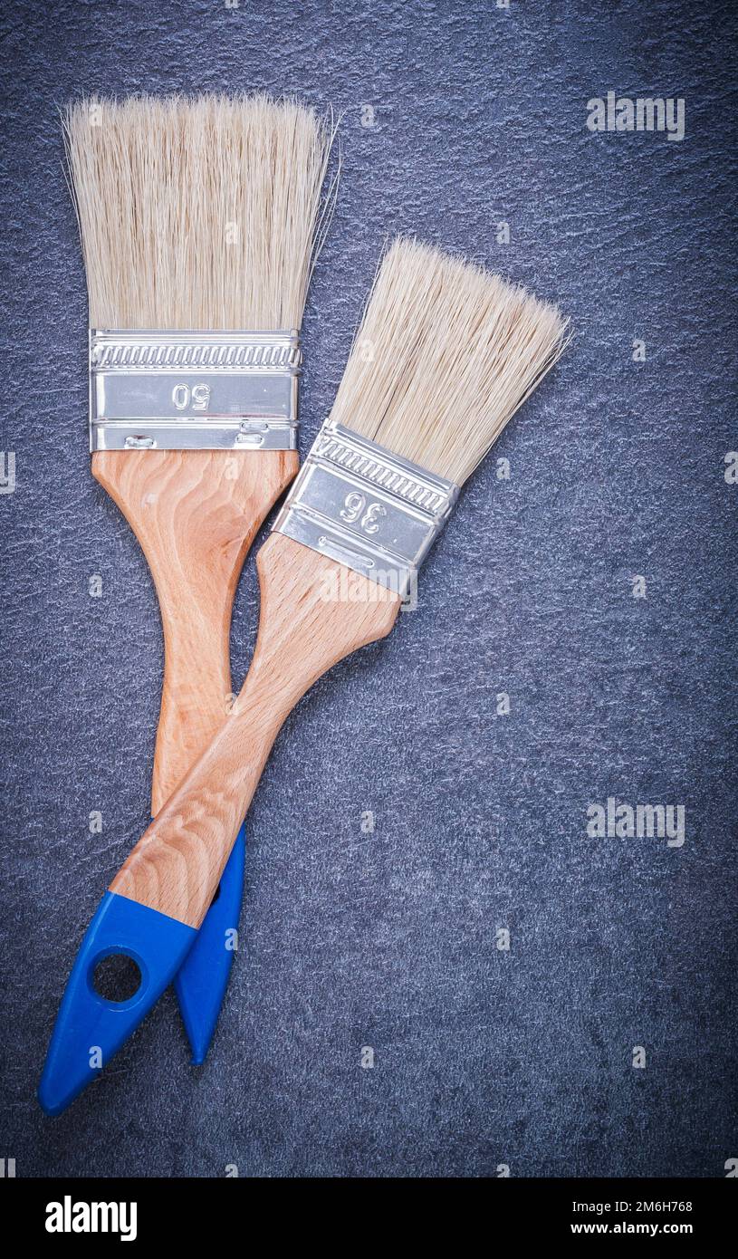 Paint brushes on black background vertical view construction concept ...