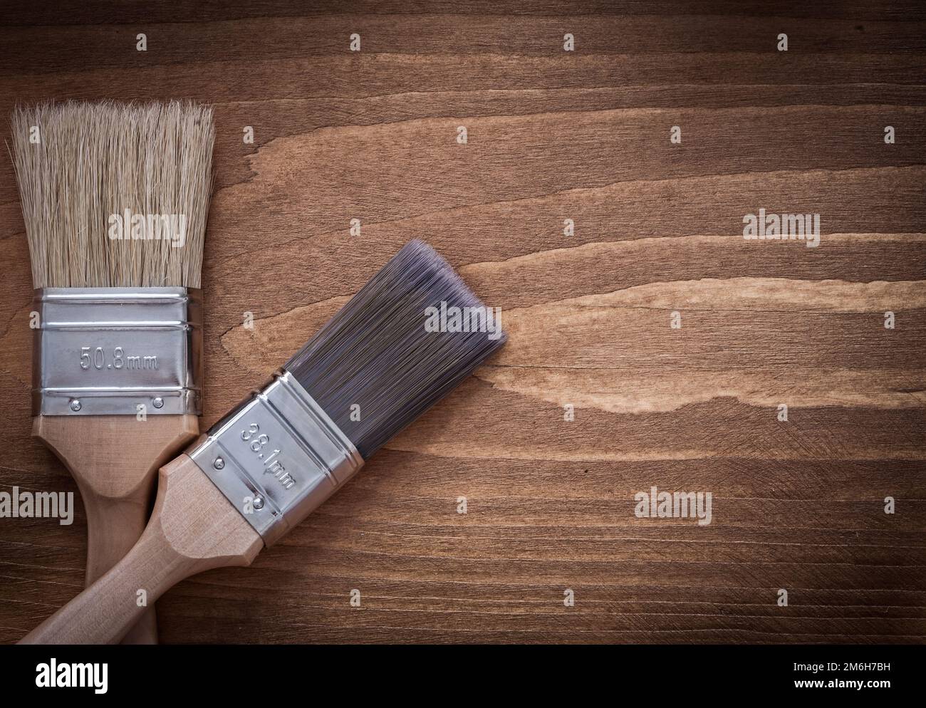 Paintbrushes with wood handles on wooden surface close up view Stock ...