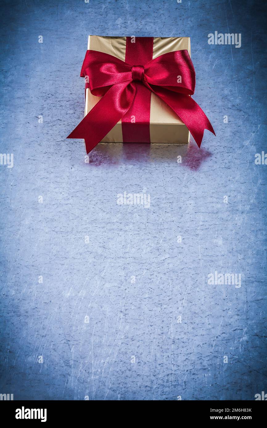Present box with red ribbon on metallic background holiday concept ...