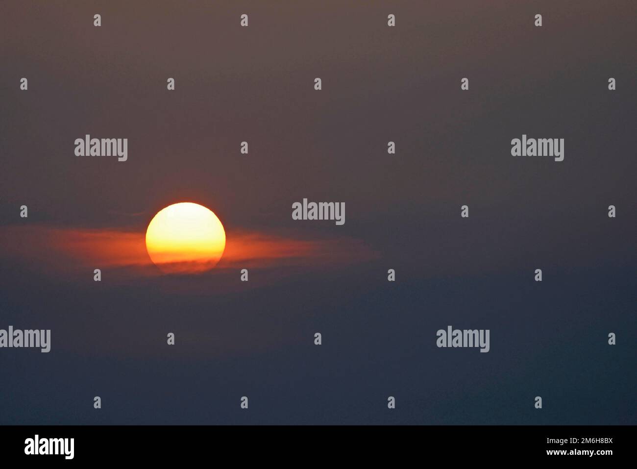 Sunrise, sun emerging from a gap in the clouds, grey sky, North Rhine ...