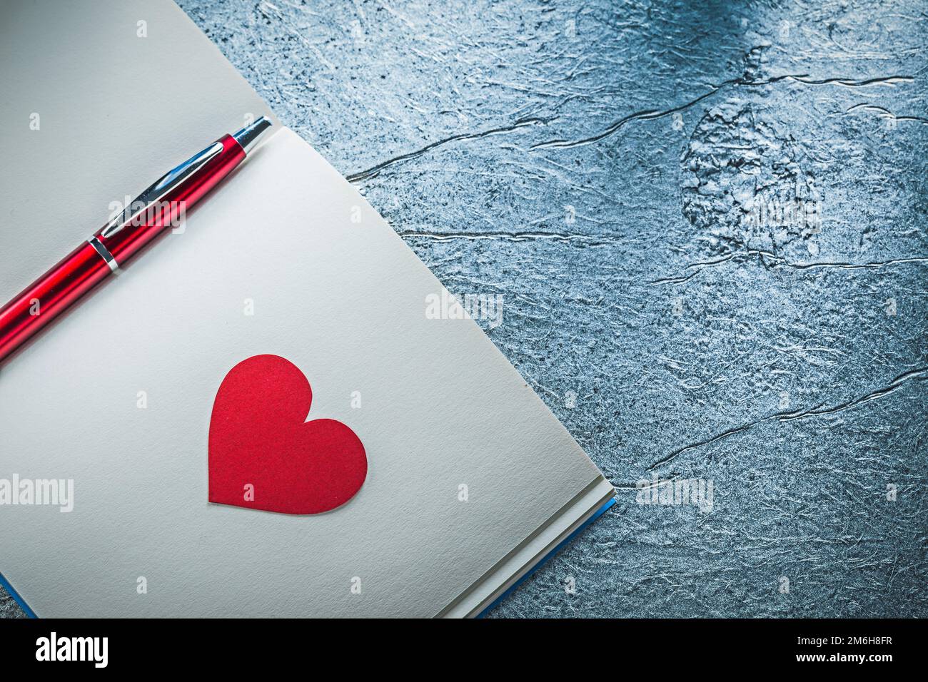 Red heart biro pen notepad on metallic background education concept ...