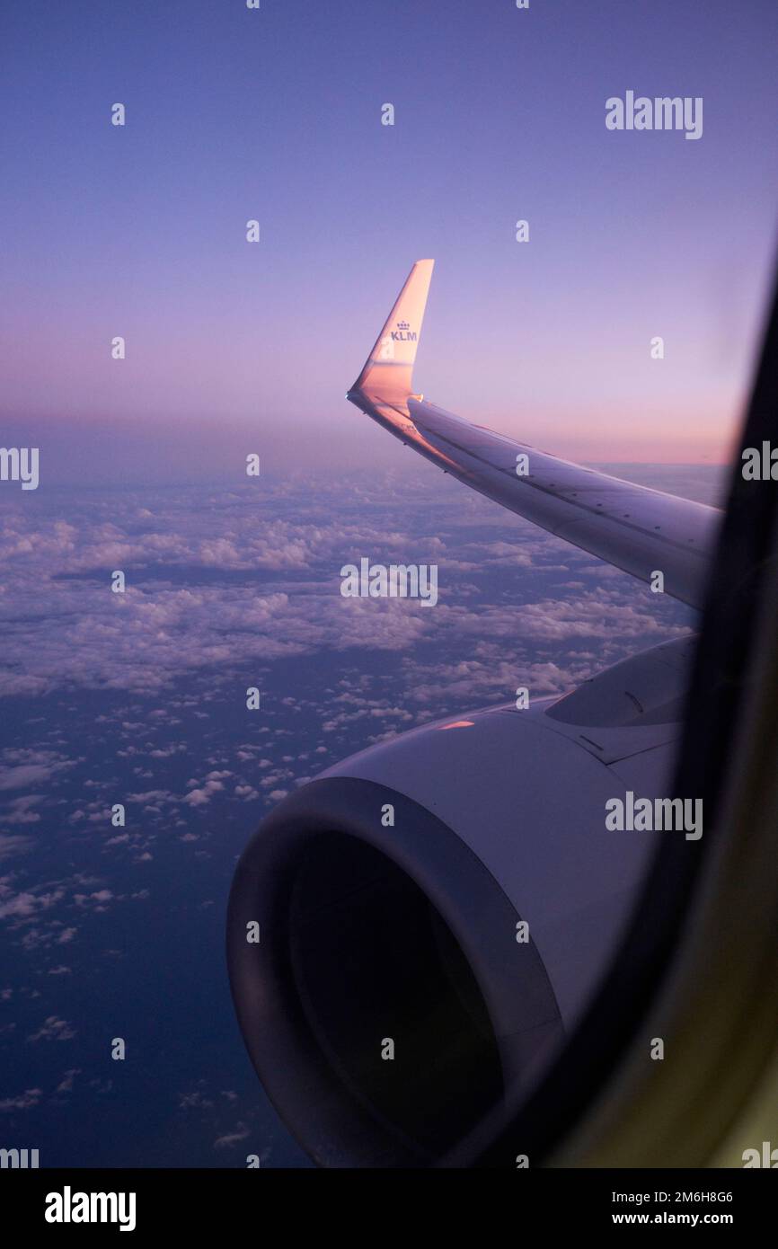 A view of the wingtip of a KLM branded aeroplane inflight at sunrise ...