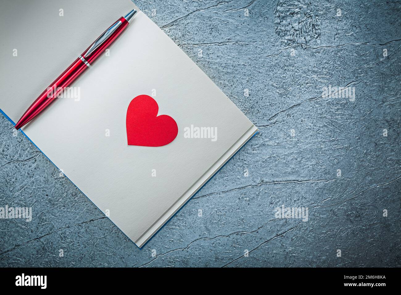 Red heart pen notepad on metallic background education concept Stock ...