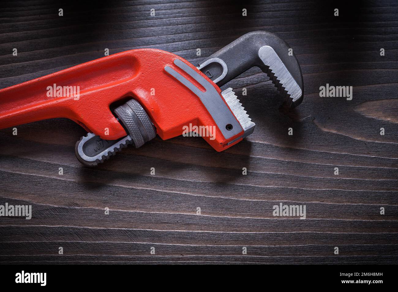 Repairing adjustable wrench on flat brown vintage board construction ...