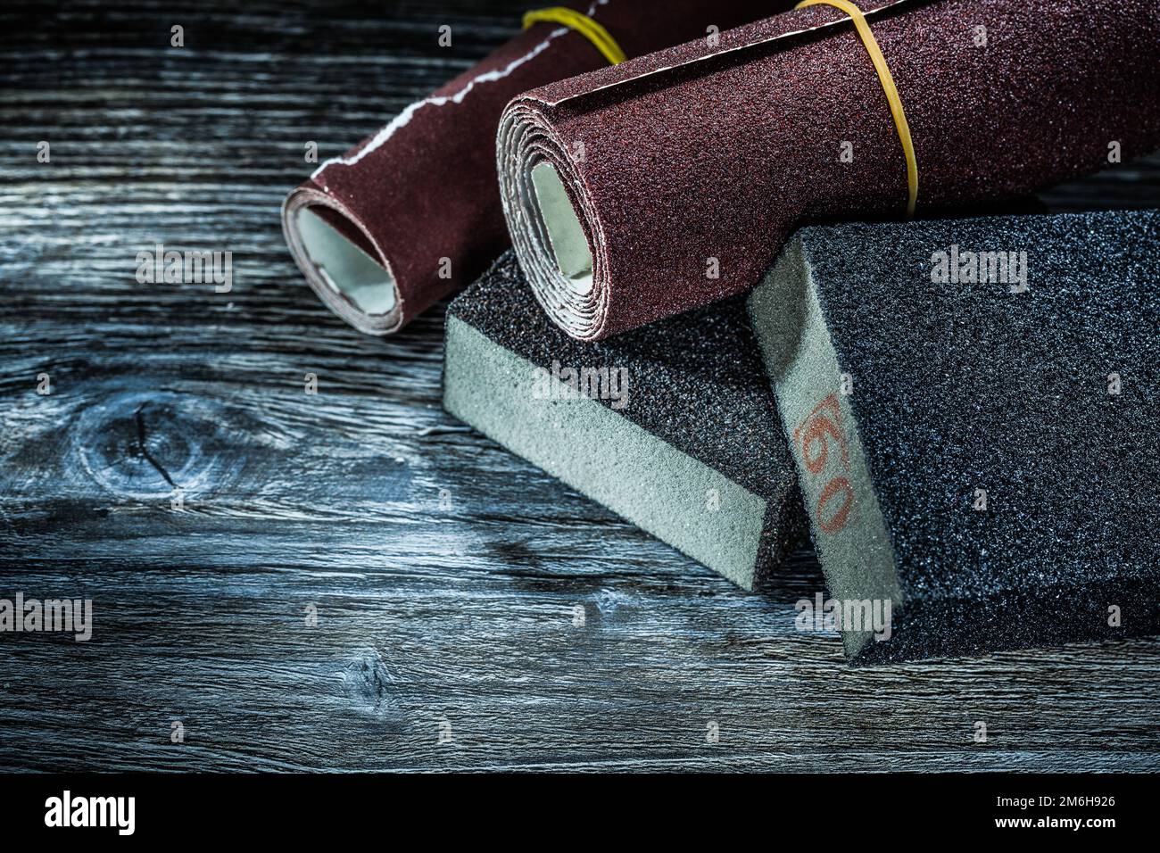 Rolled abrasive paper sponges on vintage wooden board Stock Photo - Alamy