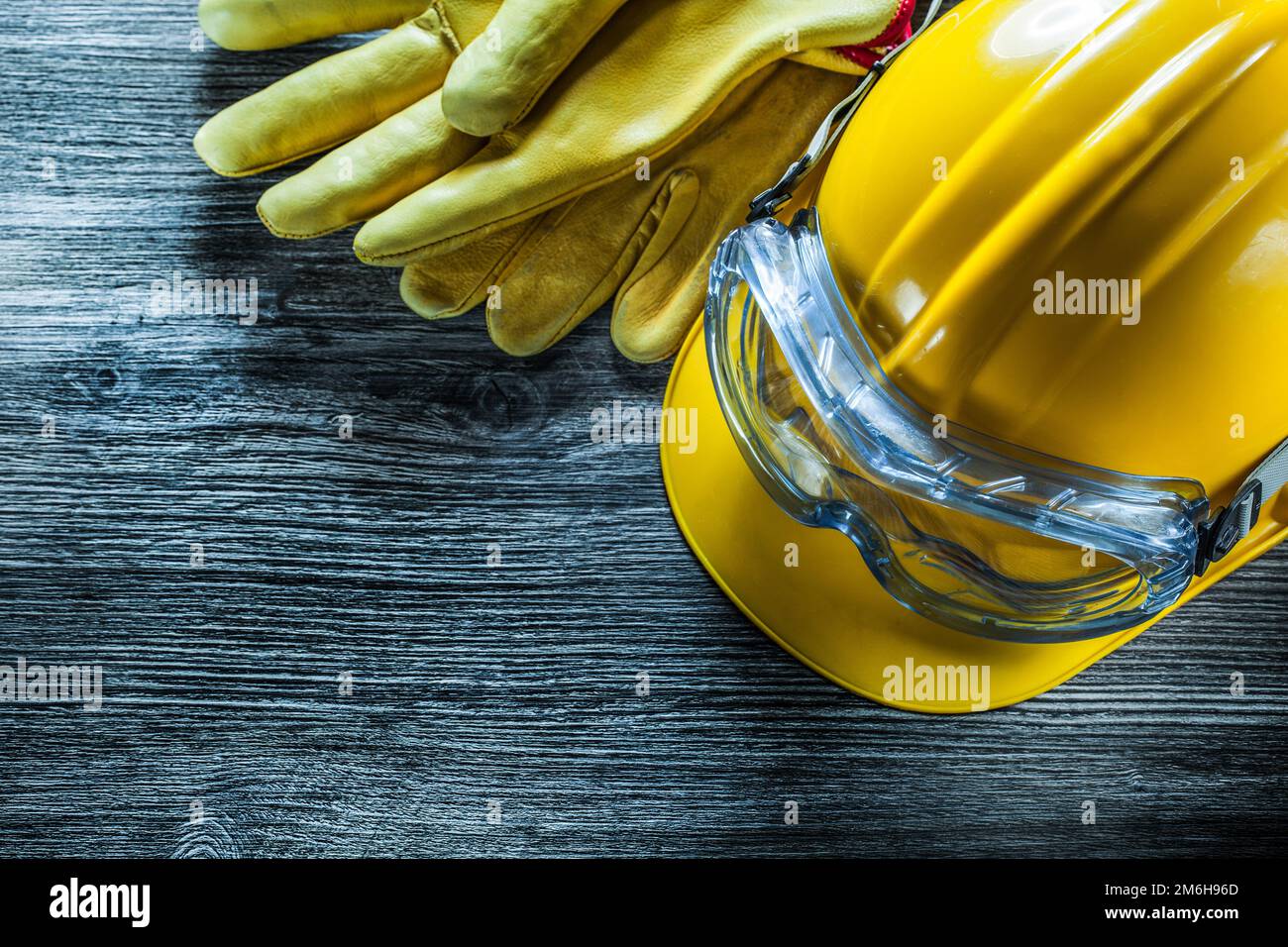 Safety glasses leather gloves building helmet on vintage wooden board ...