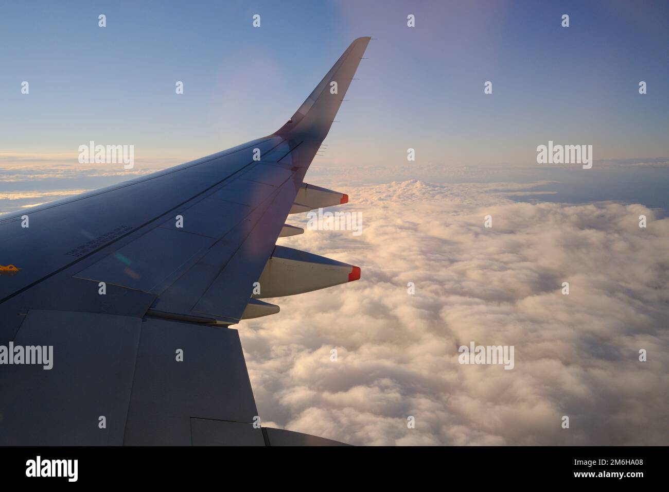 A view from a British airways plane of sunlit clouds beneath the wing ...