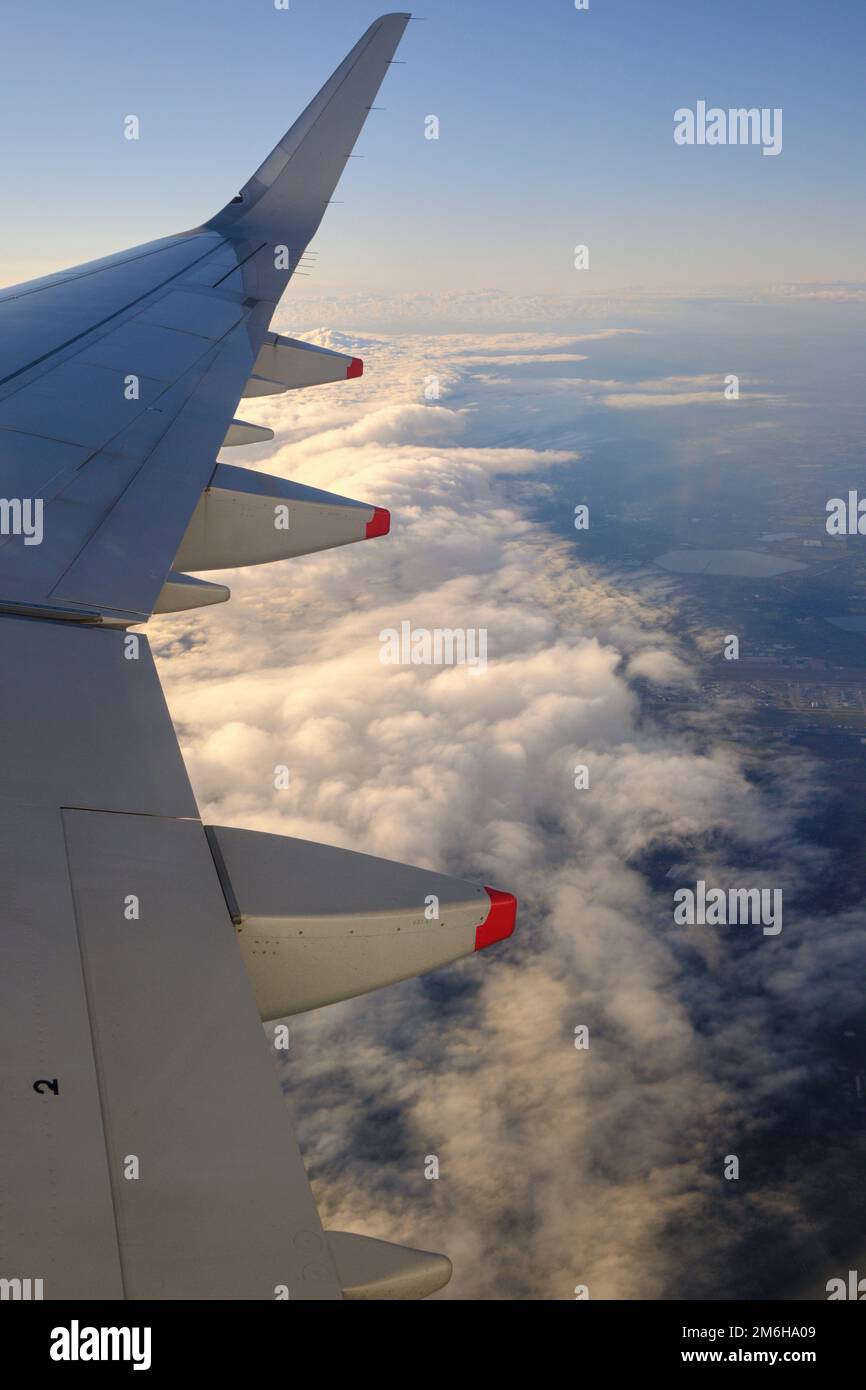 A view from a British airways plane of sunlit clouds beneath the wing ...