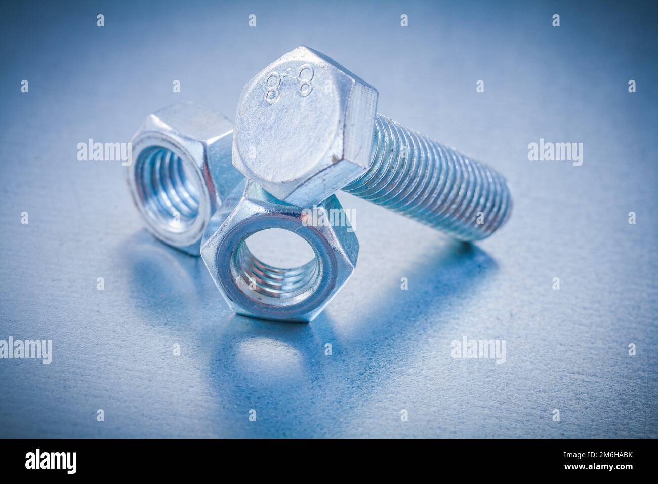 Threaded bolt detail and screw nuts on metallic background construction ...